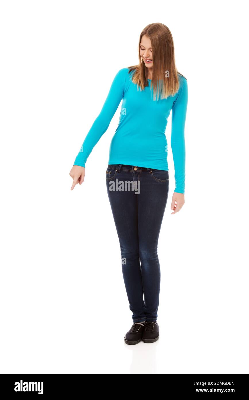 Young Woman Pointing While Standing Against White Background Stock ...