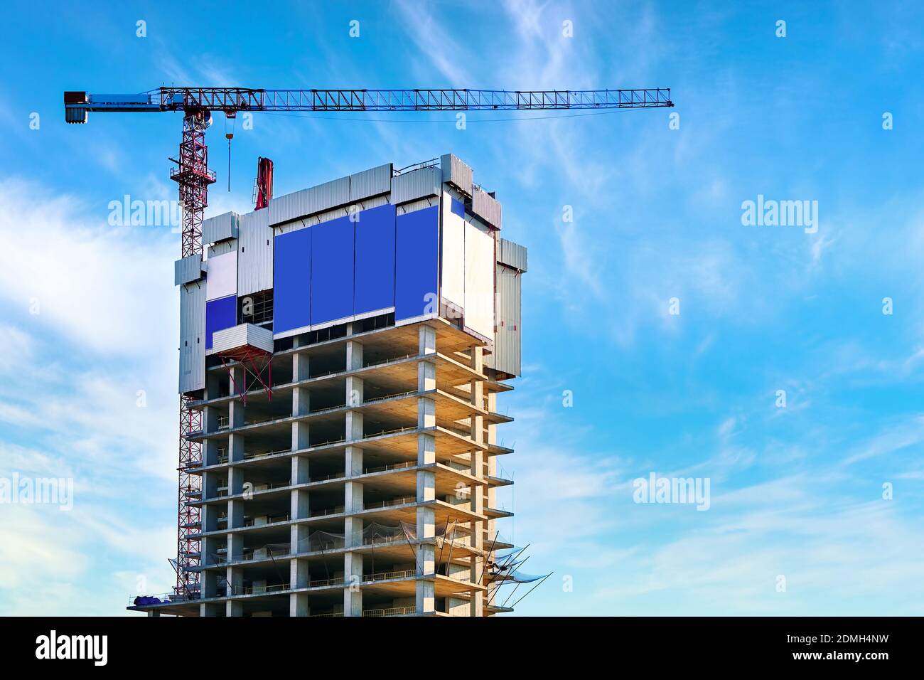 Construction crane at the top of a skyscraper building under ...