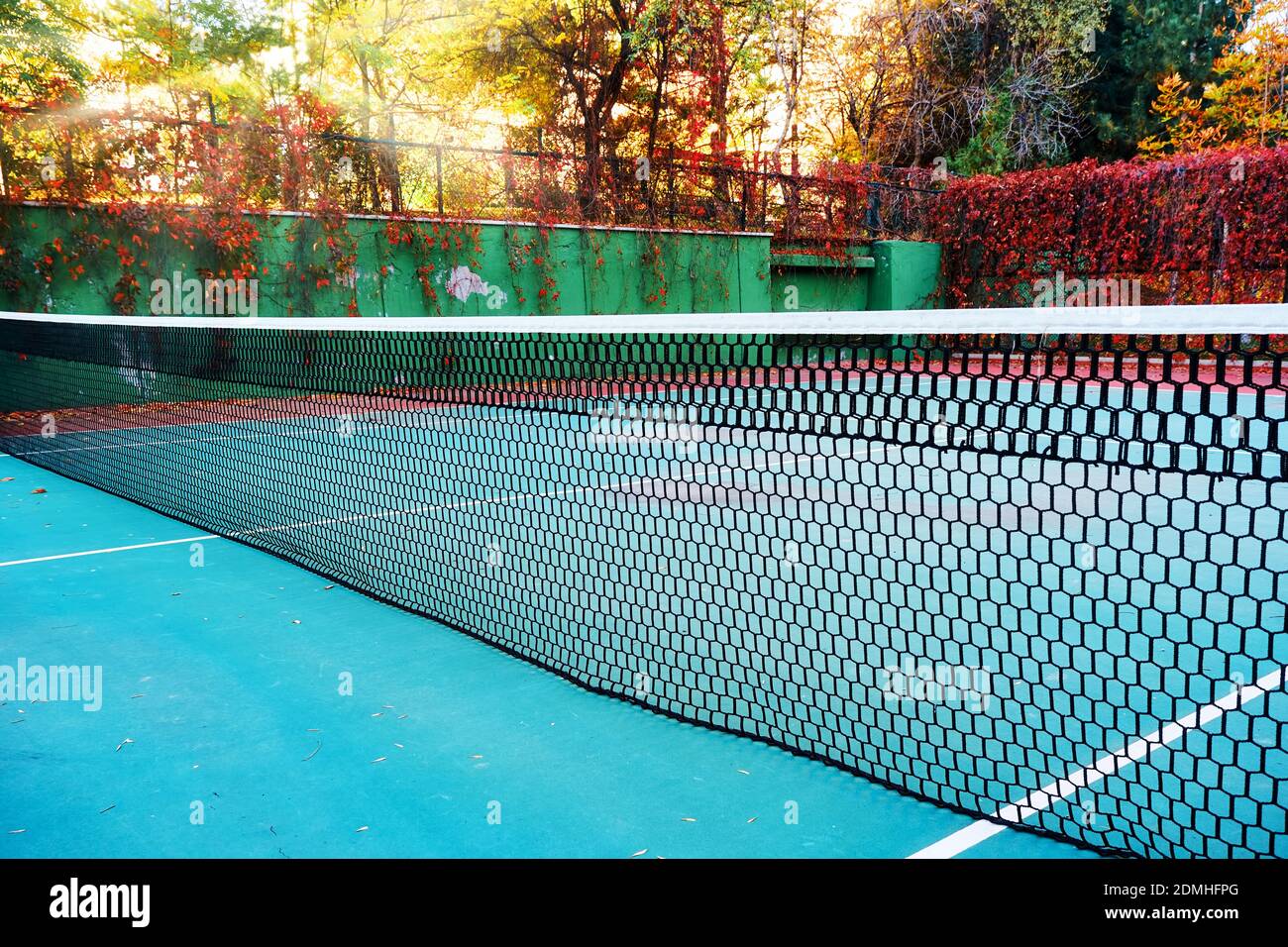 Worn clay or hard surface outdoor tennis court with net Stock Photo - Alamy