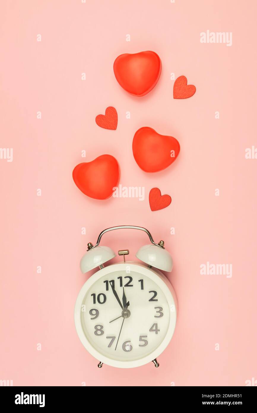 Pink Background with white alarm clock and red hearts. Creative layout ...