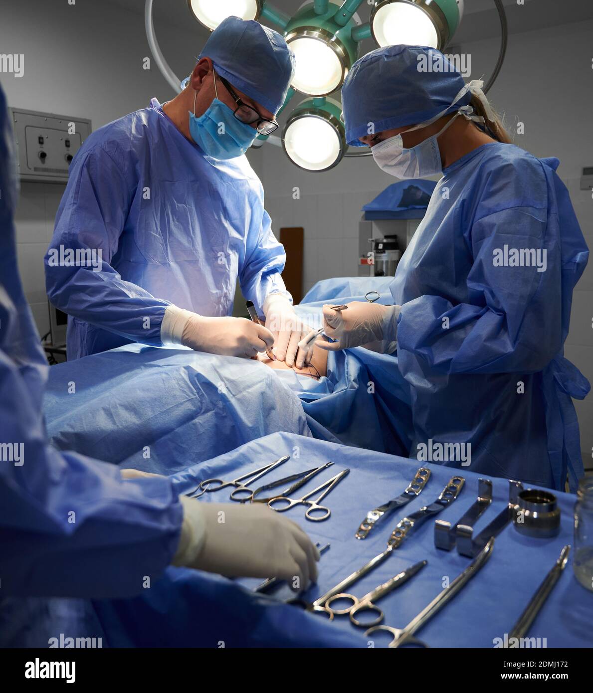 Medical team in surgical suits performing aesthetic surgery in ...