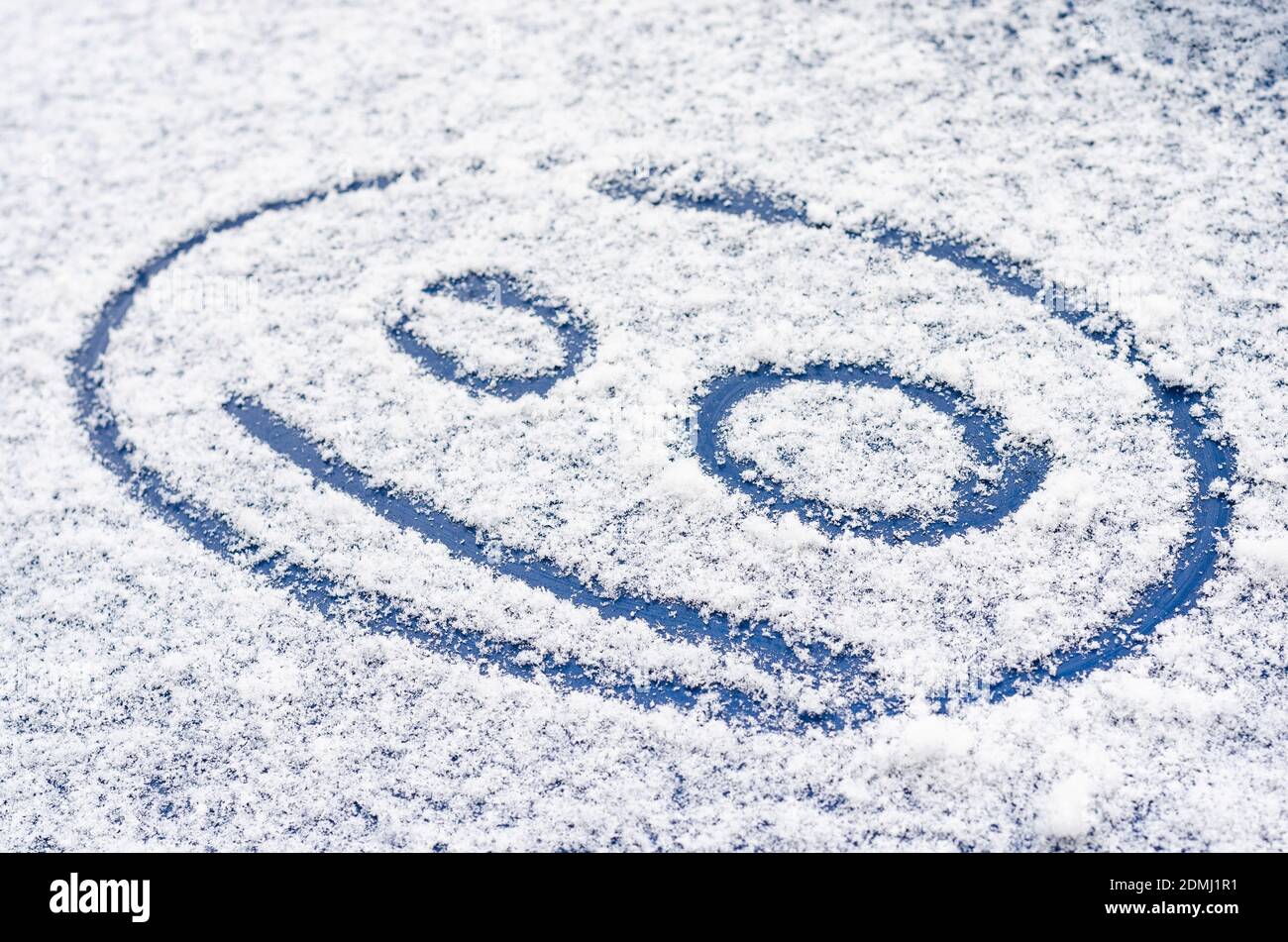 Smiling emoji face drawn on the snow Stock Photo - Alamy