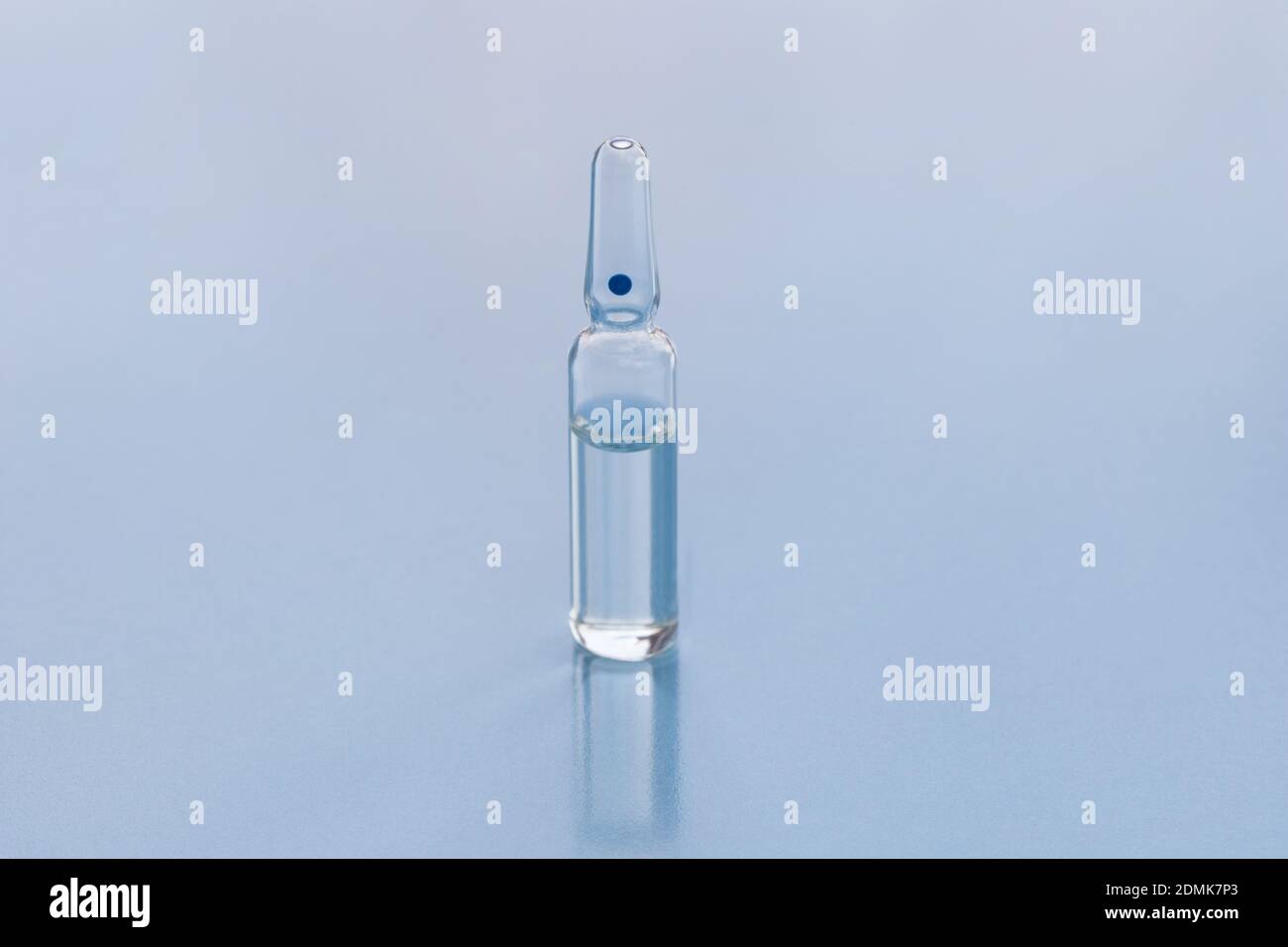 Glass ampulla for vaccination and treatment isolated on a blue ...