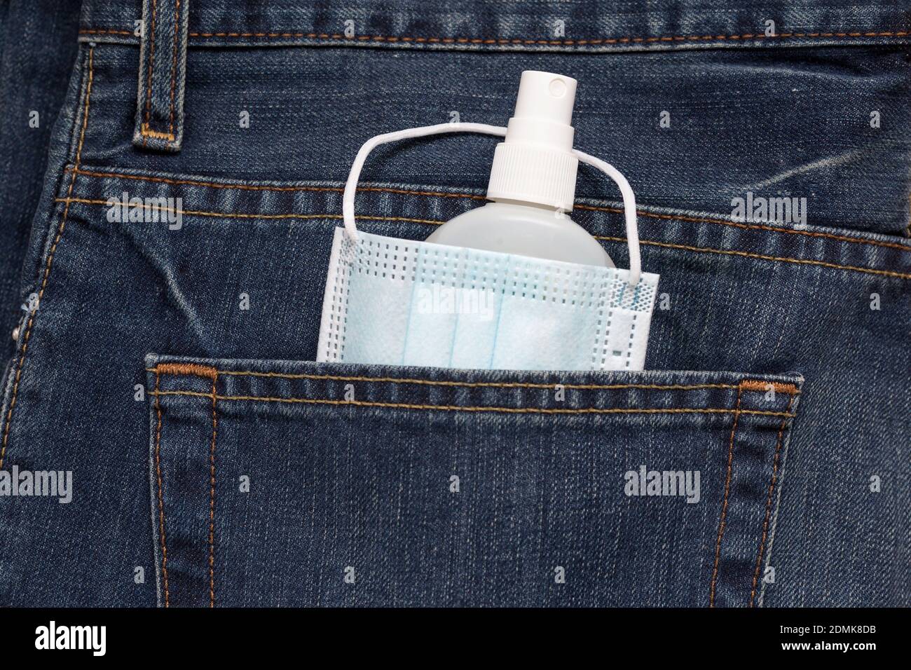 Protective face mask and hand sanitizer spray are lying in back pocket ...
