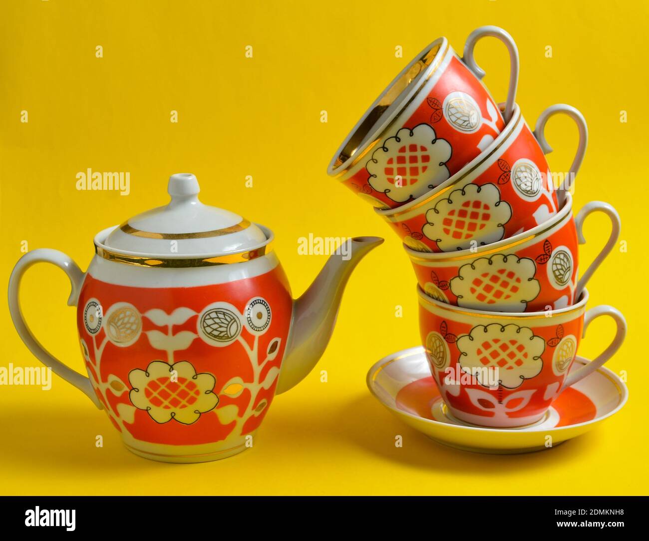 Stack of retro cups and teapot on a yellow background Stock Photo - Alamy