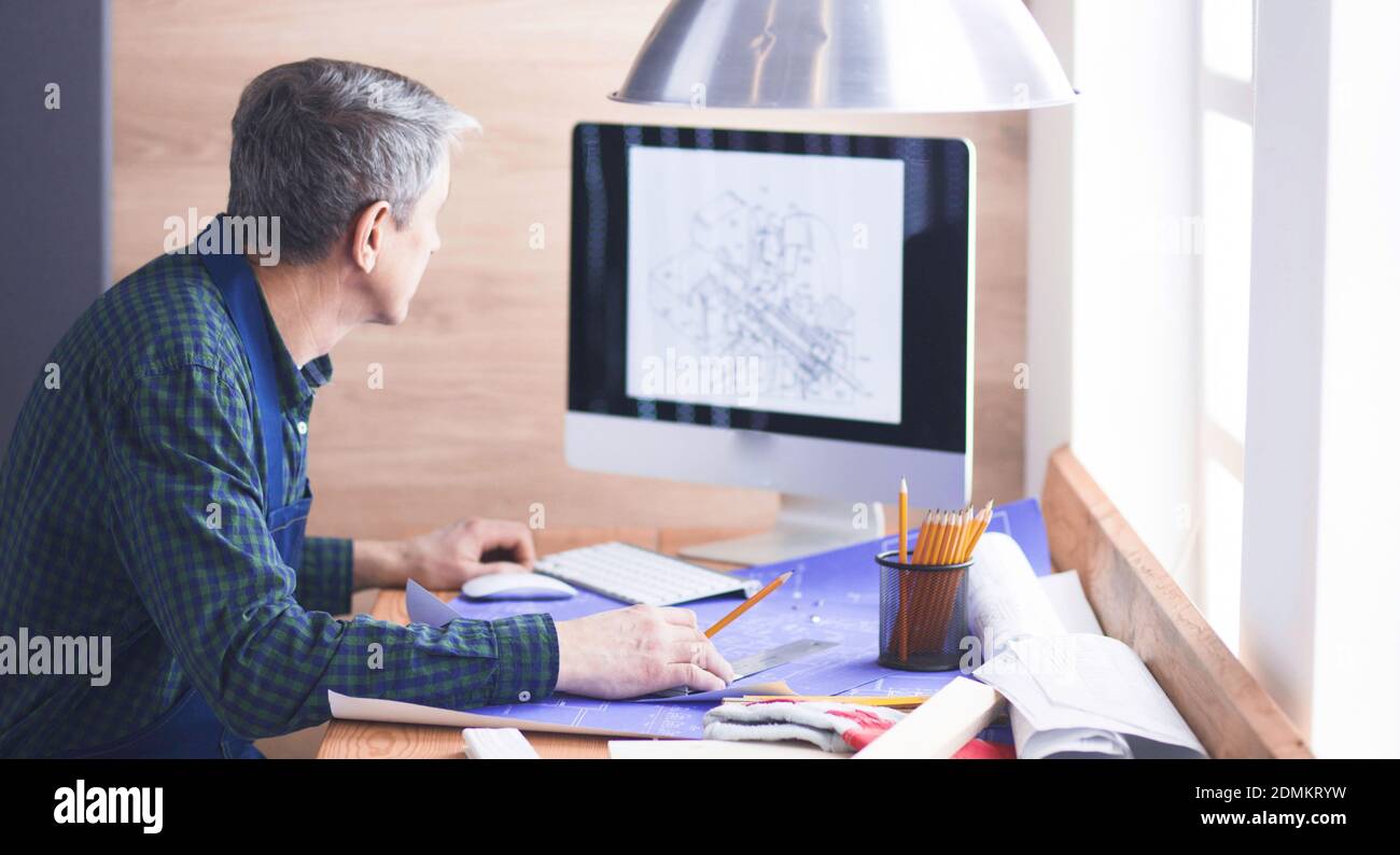 Engineer carpenter working on laptop and sketching project Stock Photo ...