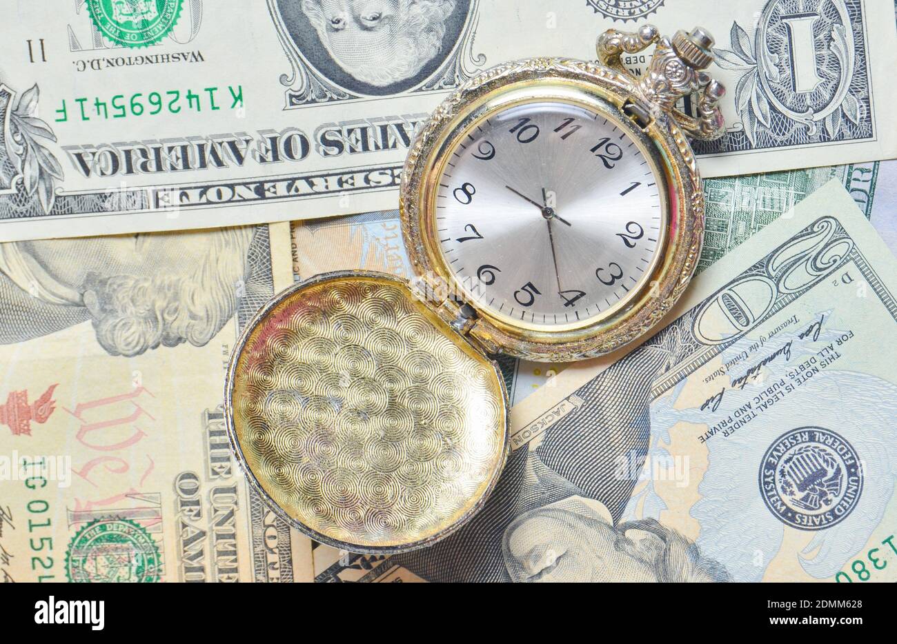 Antique pocket watch on the background of dollar bills. Time is money ...