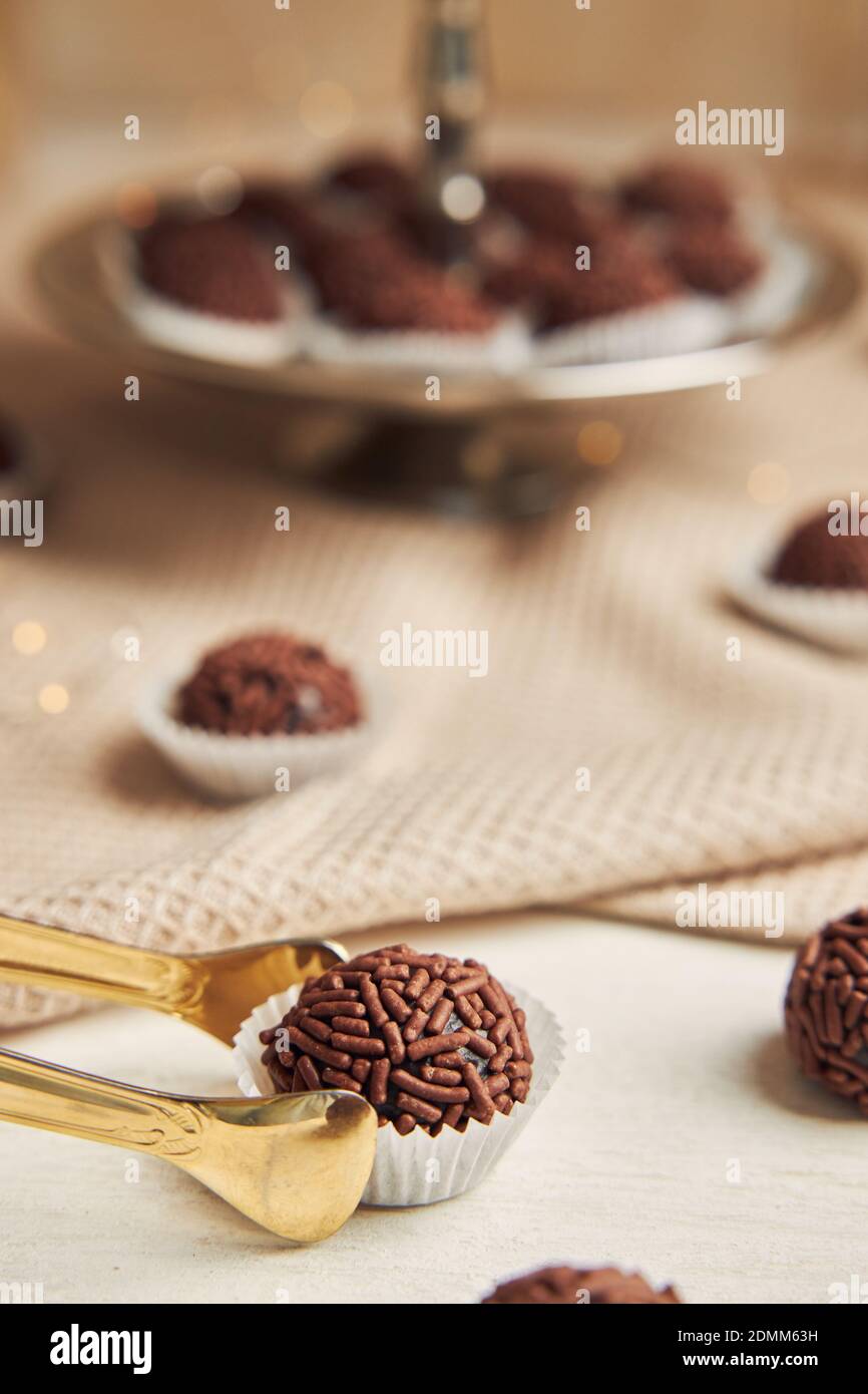 A dessert forceps putting a delicious Brazilian Brigadeiro on a white ...