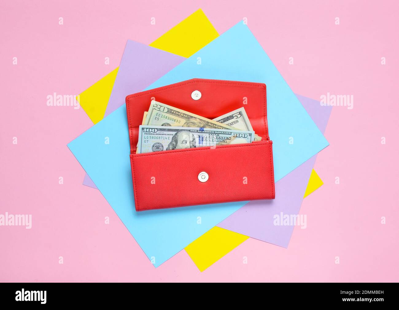 Red leather purse with dollar bills on a colored pastel background. Top ...