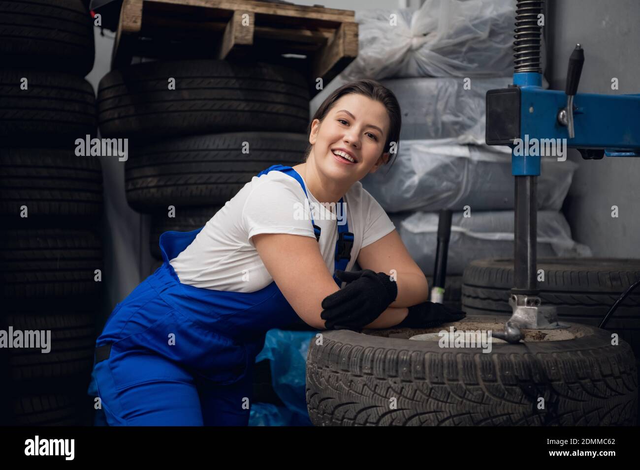 Female repairer posing next to wheels and a machine tool Stock Photo ...