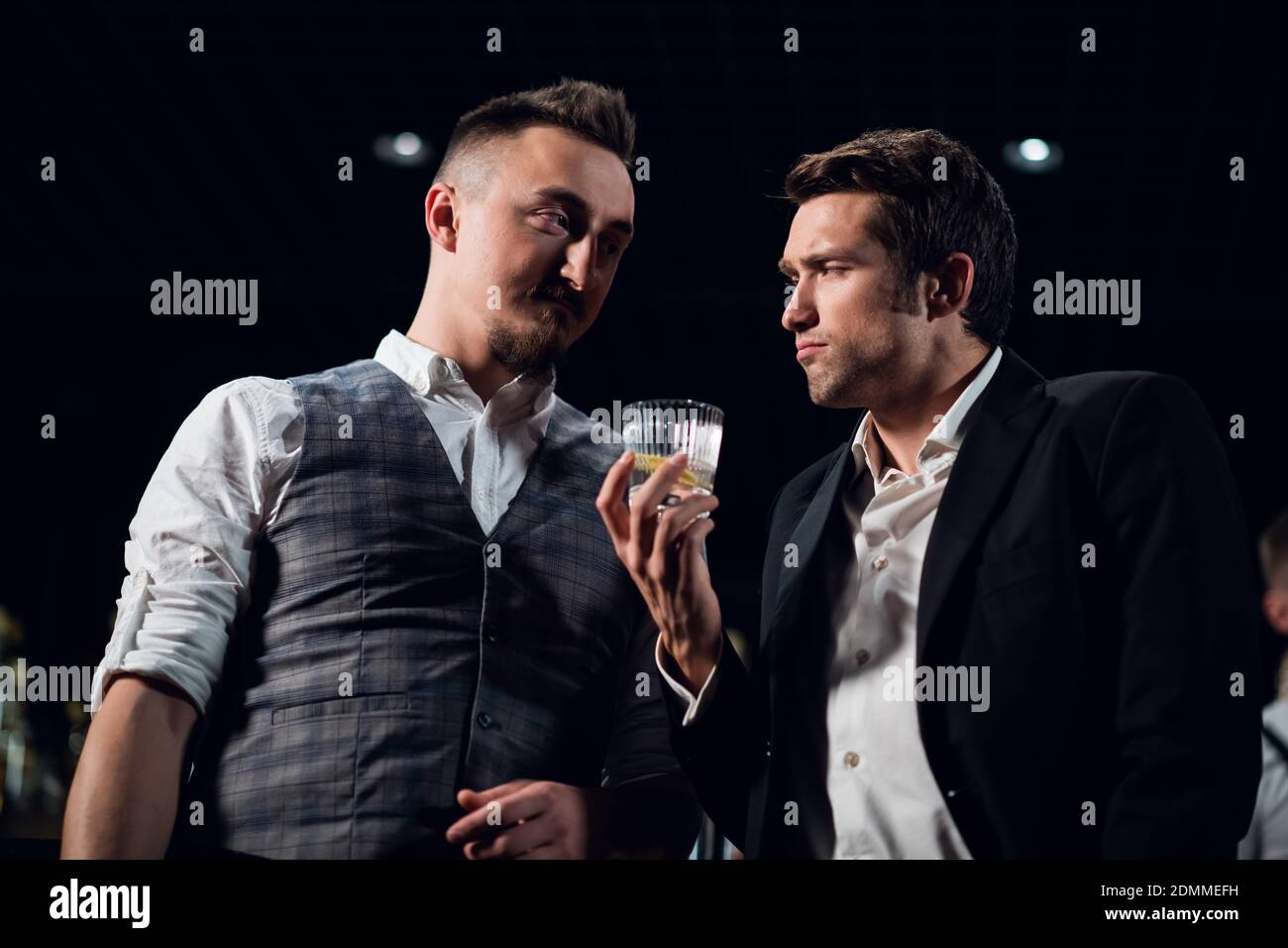 Elegant men in a nightclub talking, drinking a cocktail Stock Photo - Alamy