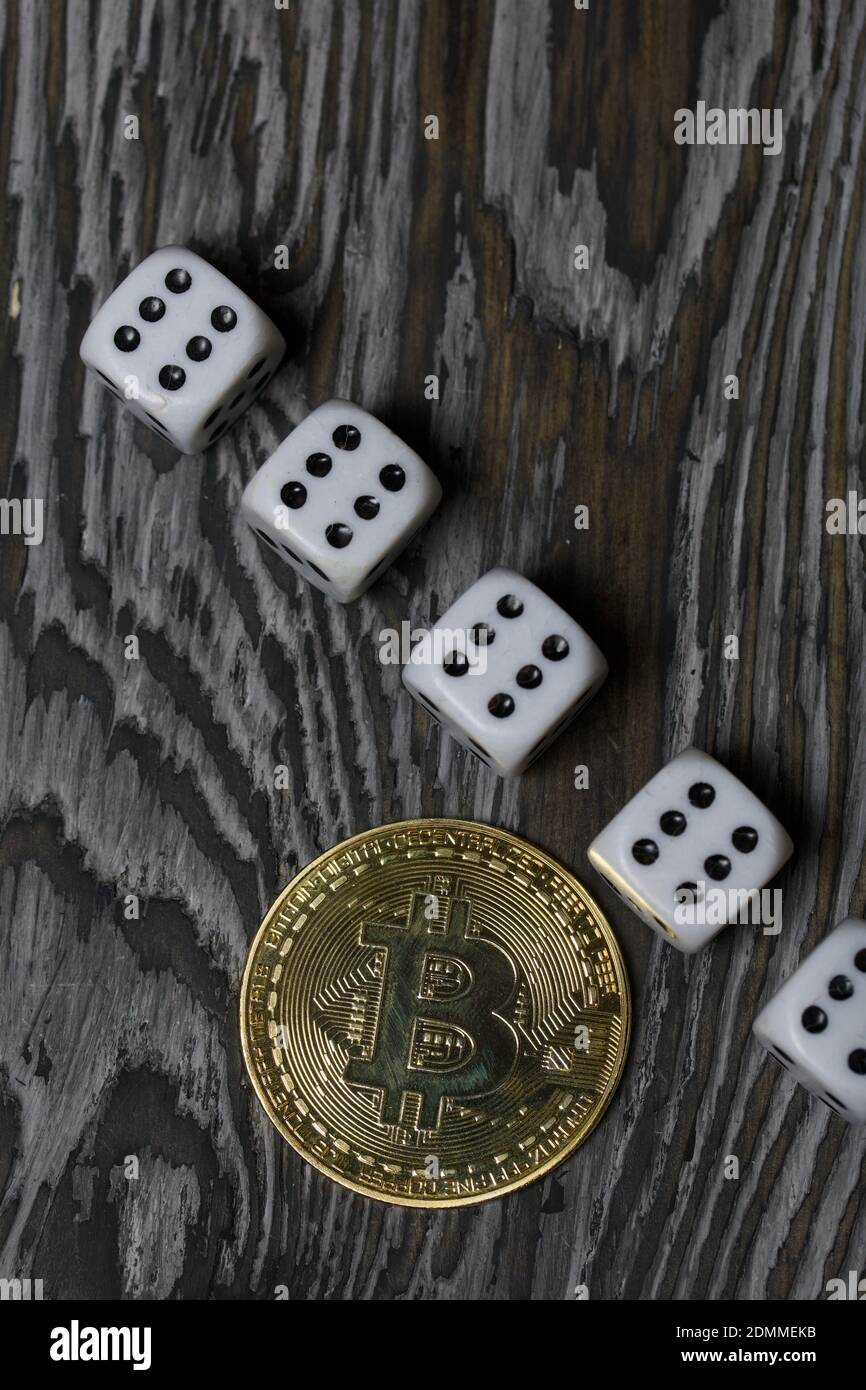 Bitcoin on black pine boards. Dice are scattered nearby Stock Photo - Alamy