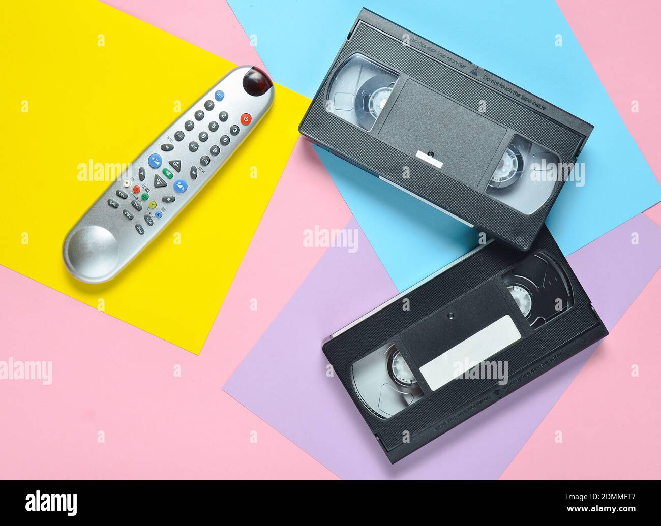 Remote, video cassette on a colored pastel background. Retro ...