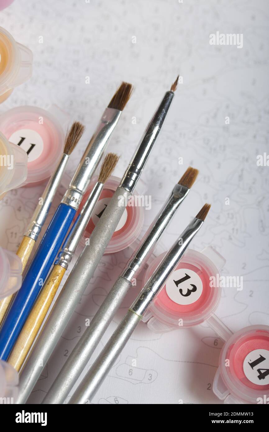 Brushes and paints for painting. On canvas with numbered sections ...