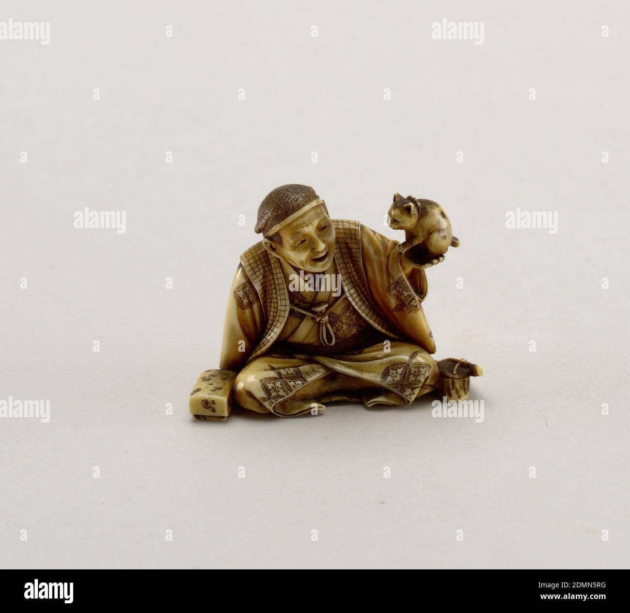 Figure, Ivory, Sitting man with crossed legs, holding cat on his raised ...
