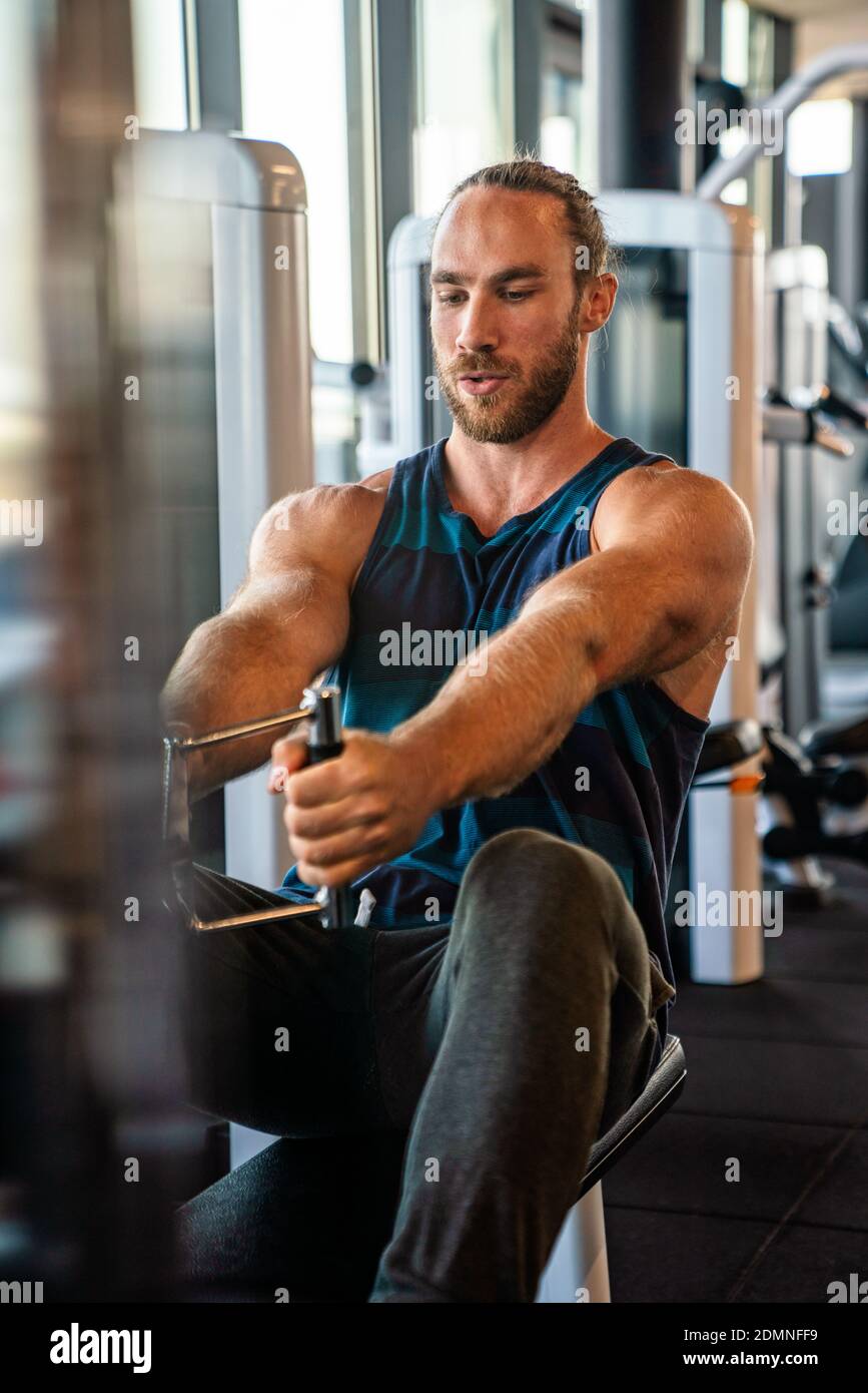 Muscular man working out in gym doing exercises to stay healthy Stock ...