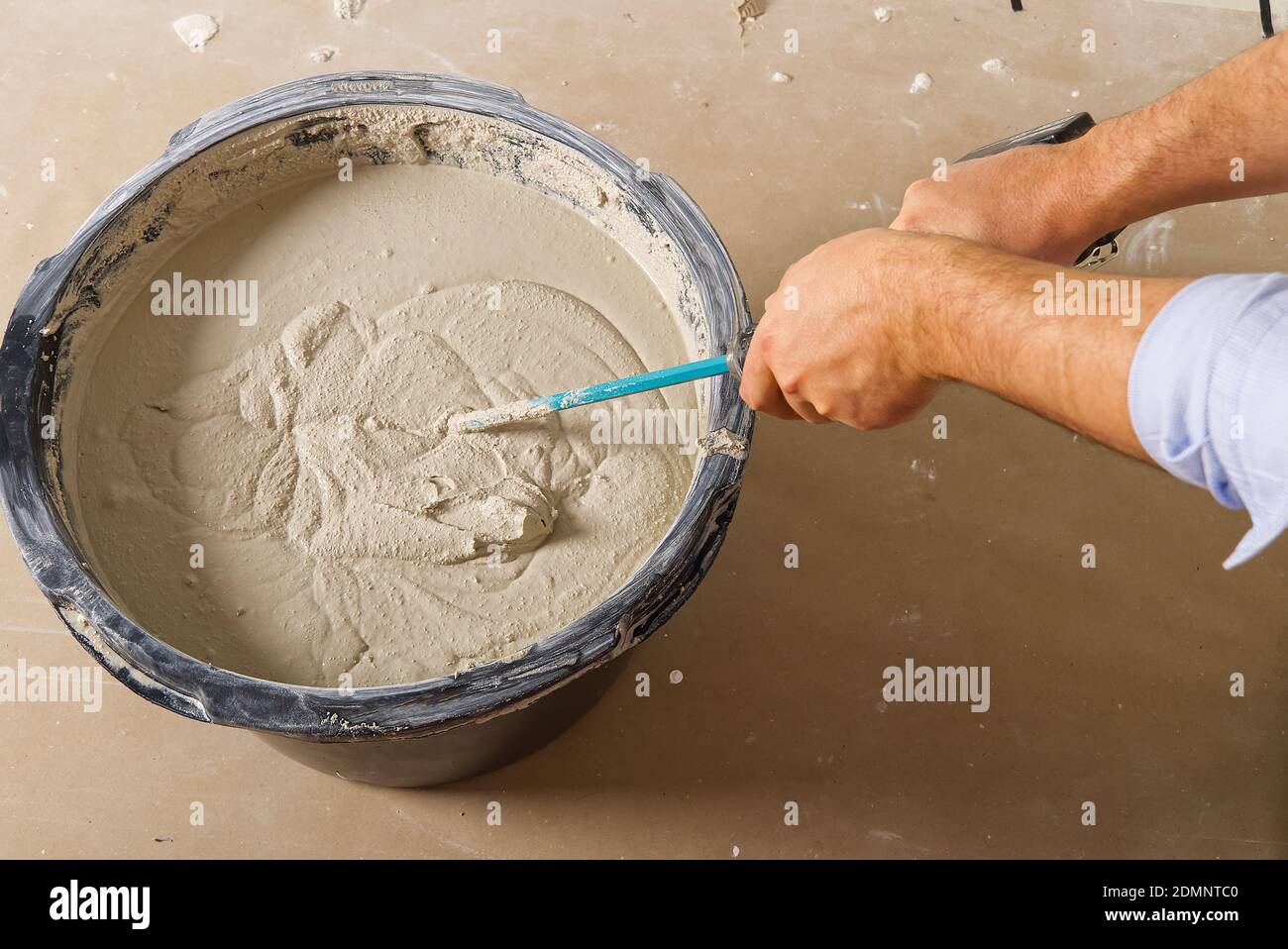 the master mixes the plaster in a bucket. Flat house renovation, master ...