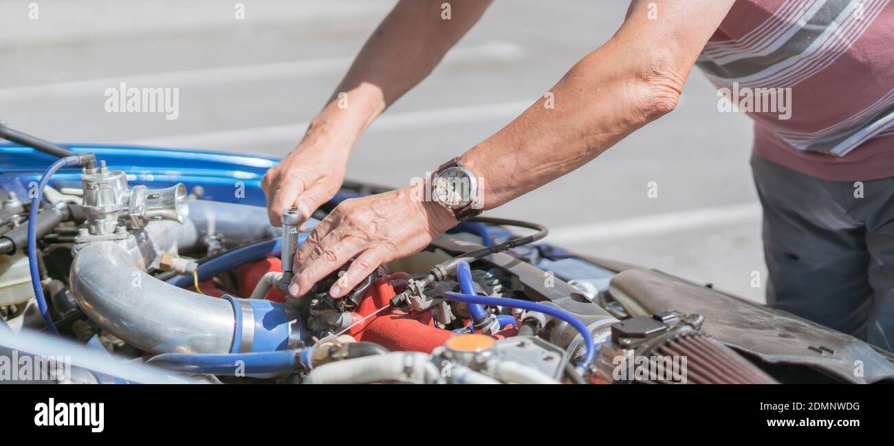 hobby of the senior man, old person fixing the car engine outdoors ...
