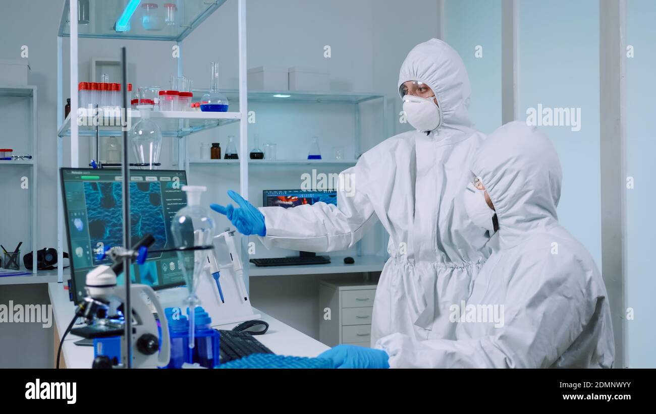Biotechnology scientist wearing ppe suit researching in equipped ...