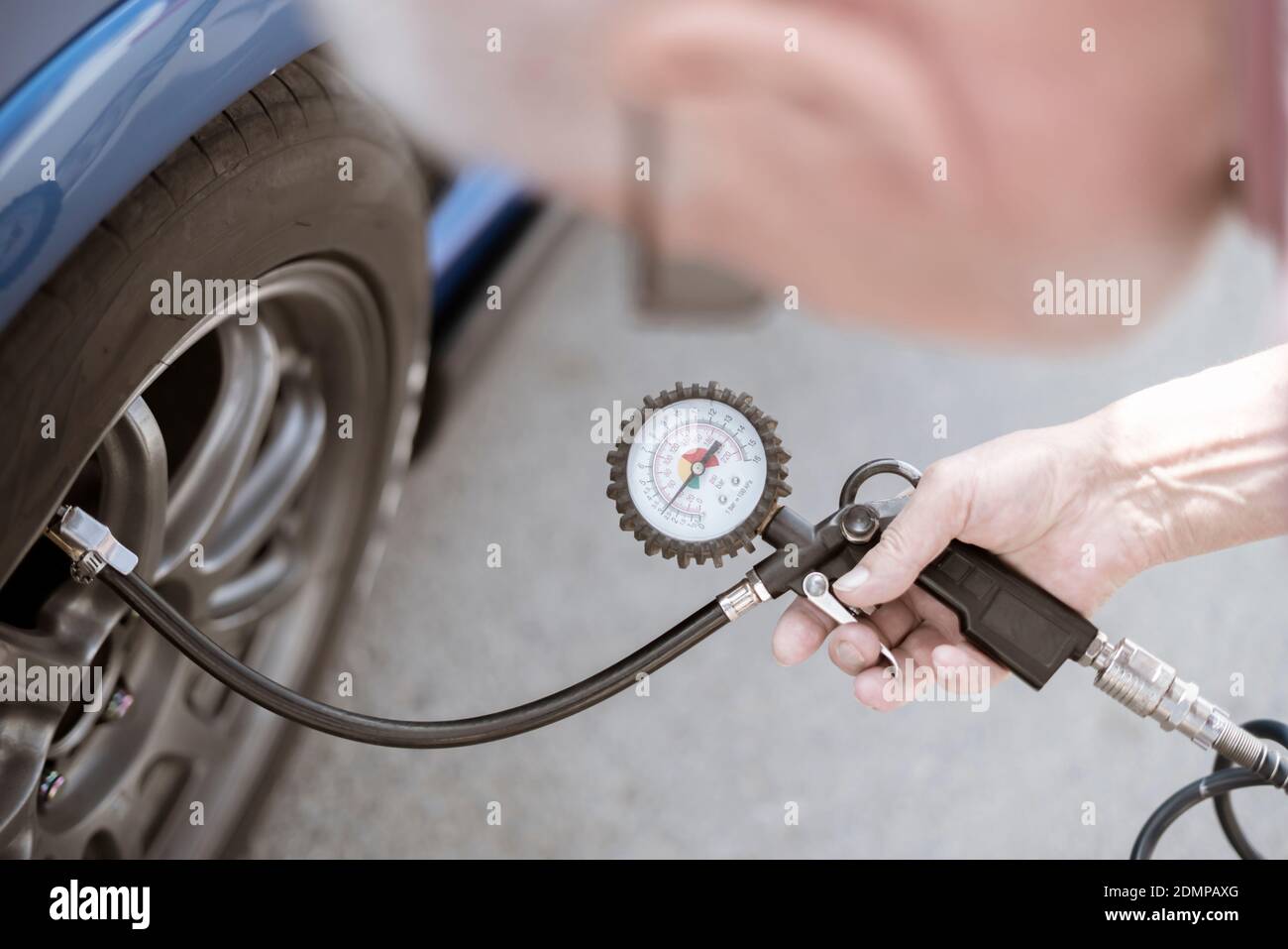 person pump up the car wheels tires with a compressor with manometer ...