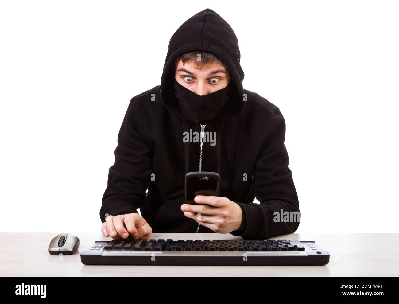 Surprised Hacker with a Mobile Phone and the Computer Keyboard on the ...