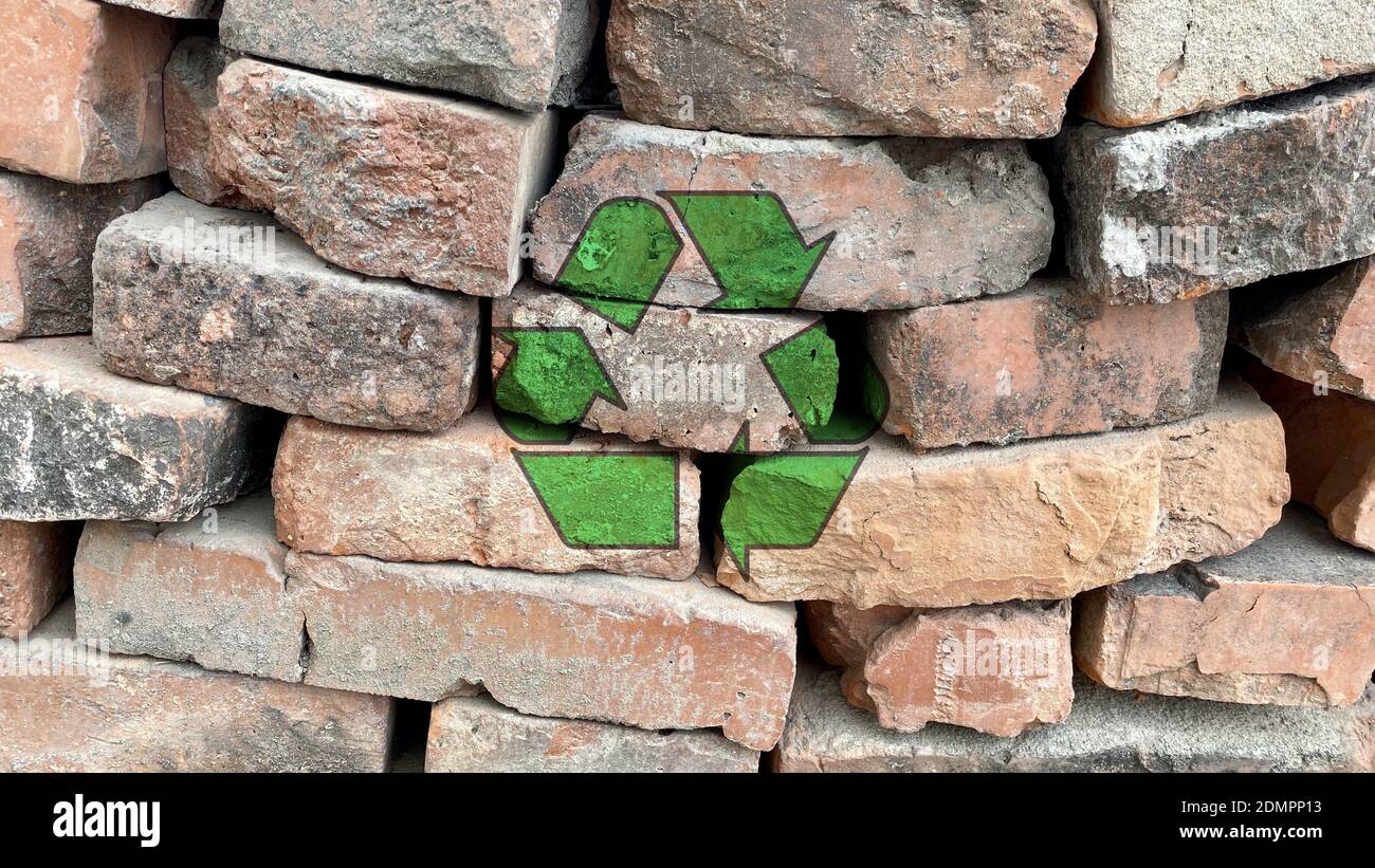 A green recycling icon on red bricks pile Stock Photo - Alamy