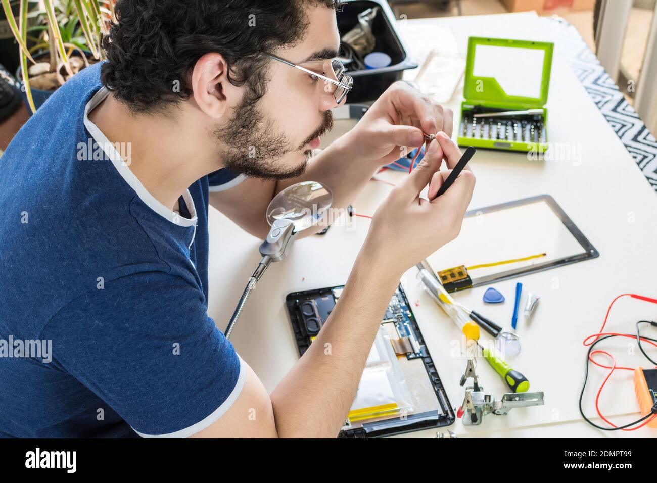 A computer repairman repairing components of electronic device Stock ...