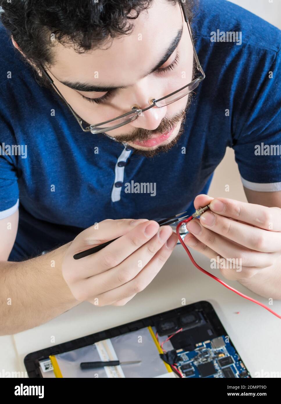 A computer repairman repairing components of electronic device Stock ...