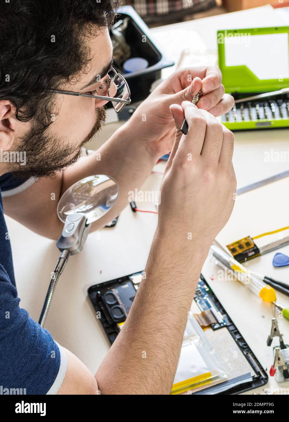 A computer repairman repairing components of electronic device Stock ...