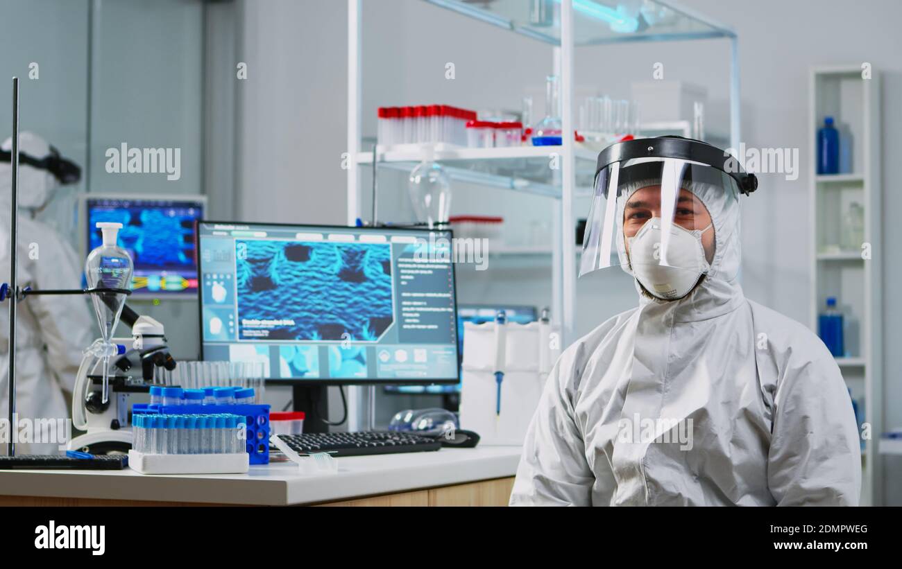 Close up of tired chemist man doctor in coverall working in scientific ...