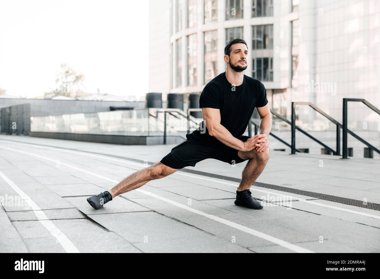 Runner doing side lunges. Portrait of sporty man doing stretching ...