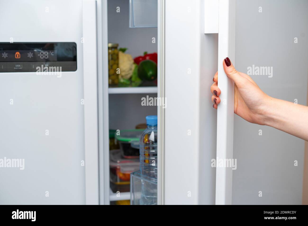 Woman opening fridge door hi-res stock photography and images - Alamy