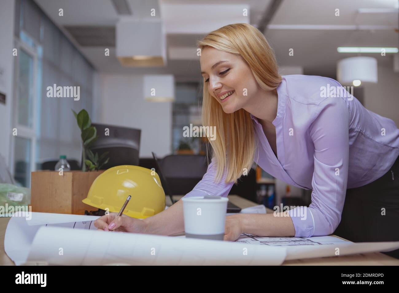 Architectural studio concept. Beautiful cheerful female engineer ...