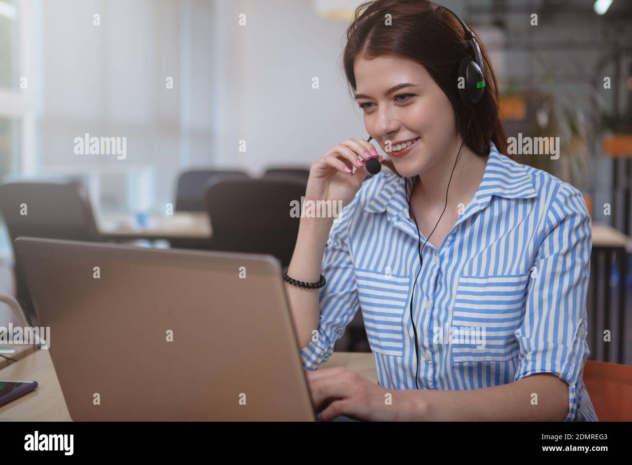 Lovely young female call center worker smiling joyfully, answering ...