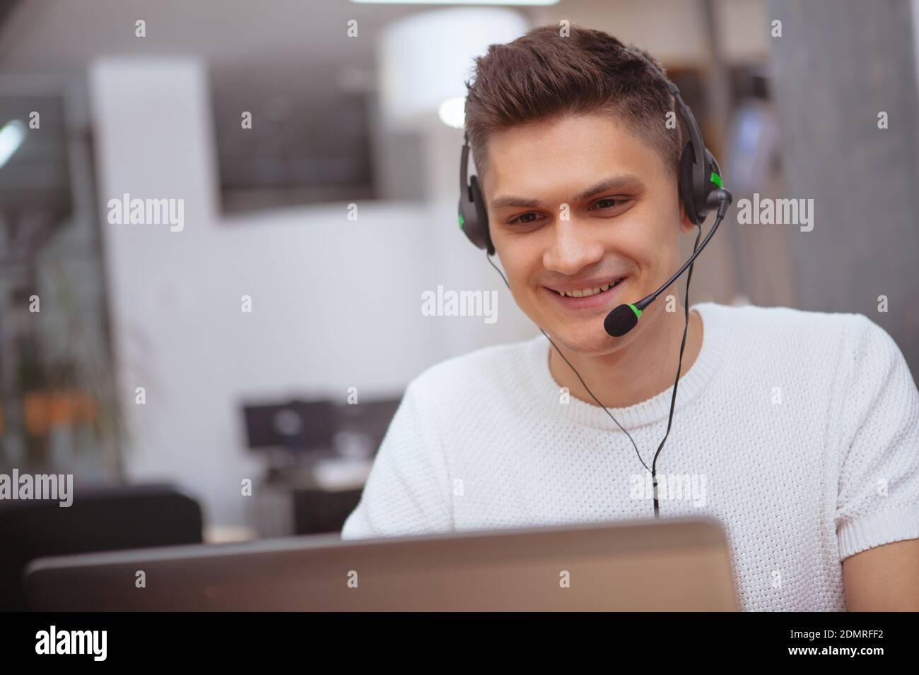 Handsome young man smiling, playing video games on computer, wearing ...