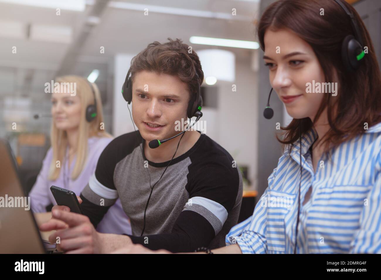 Group of young people working at customer services call center ...
