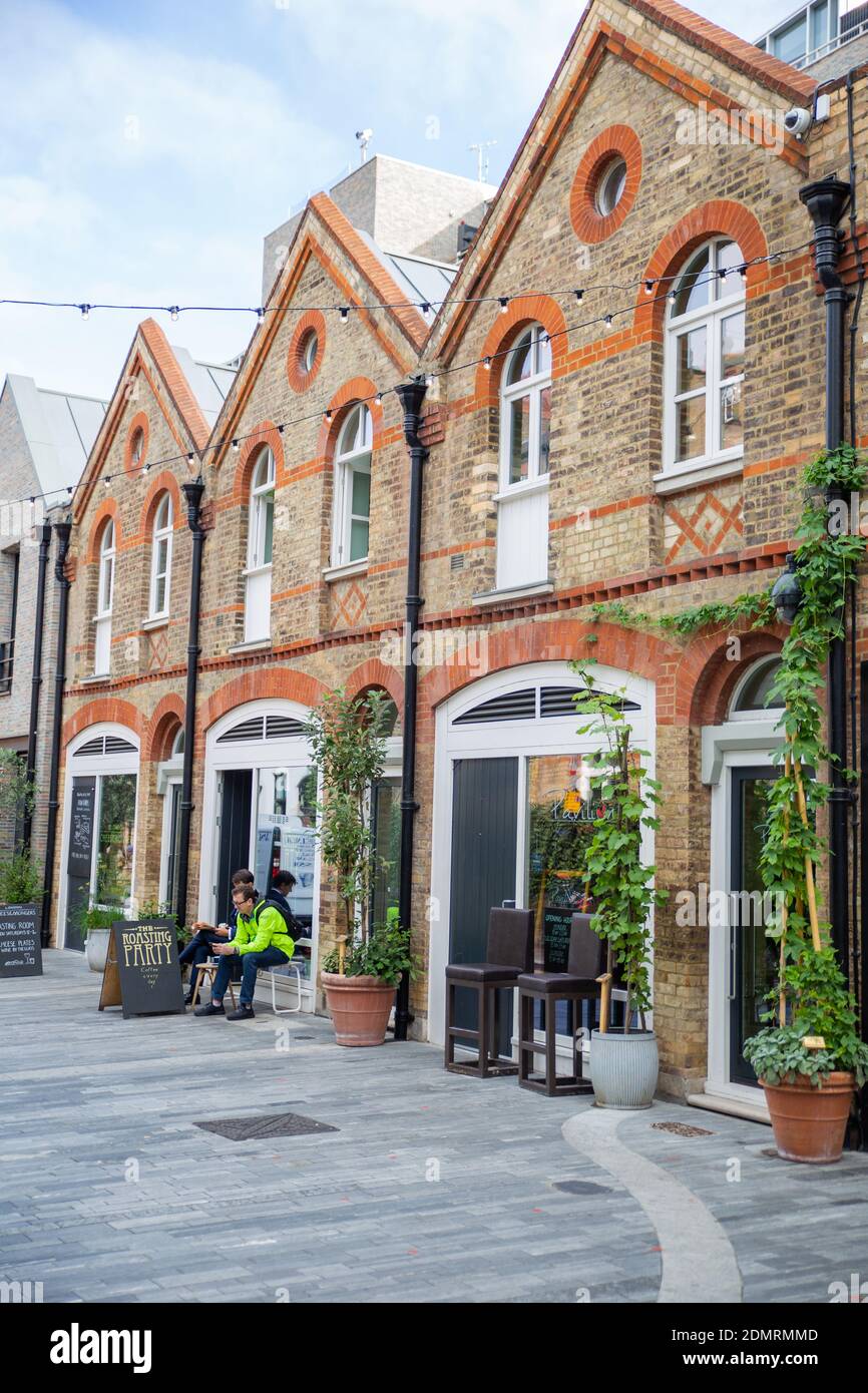 Row of brick buildings in Pavilion Road with people and plants outside ...