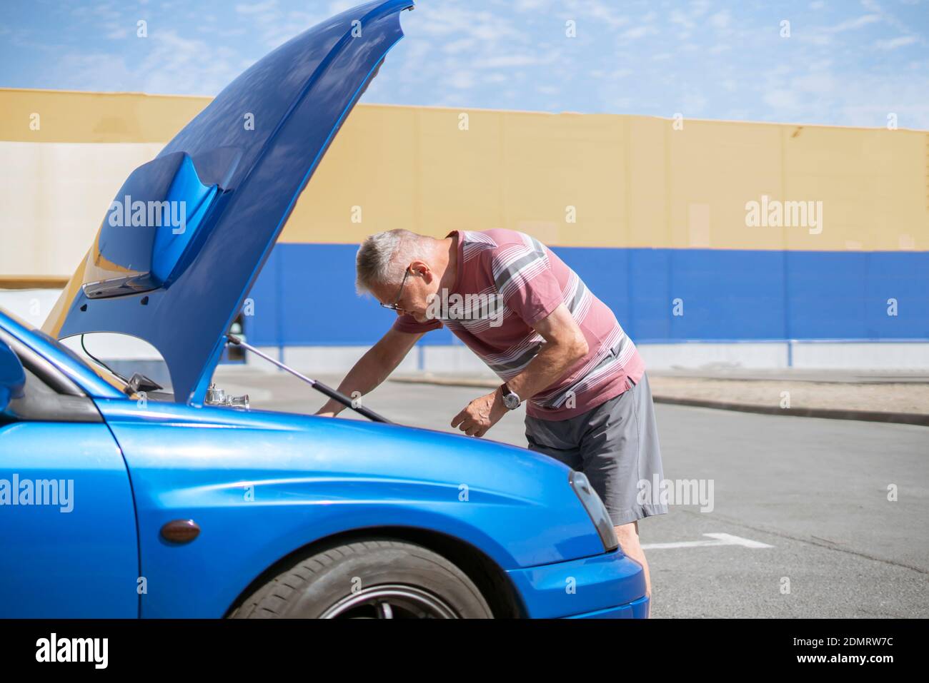 hobby of the senior man, old person fixing the car engine outdoors ...