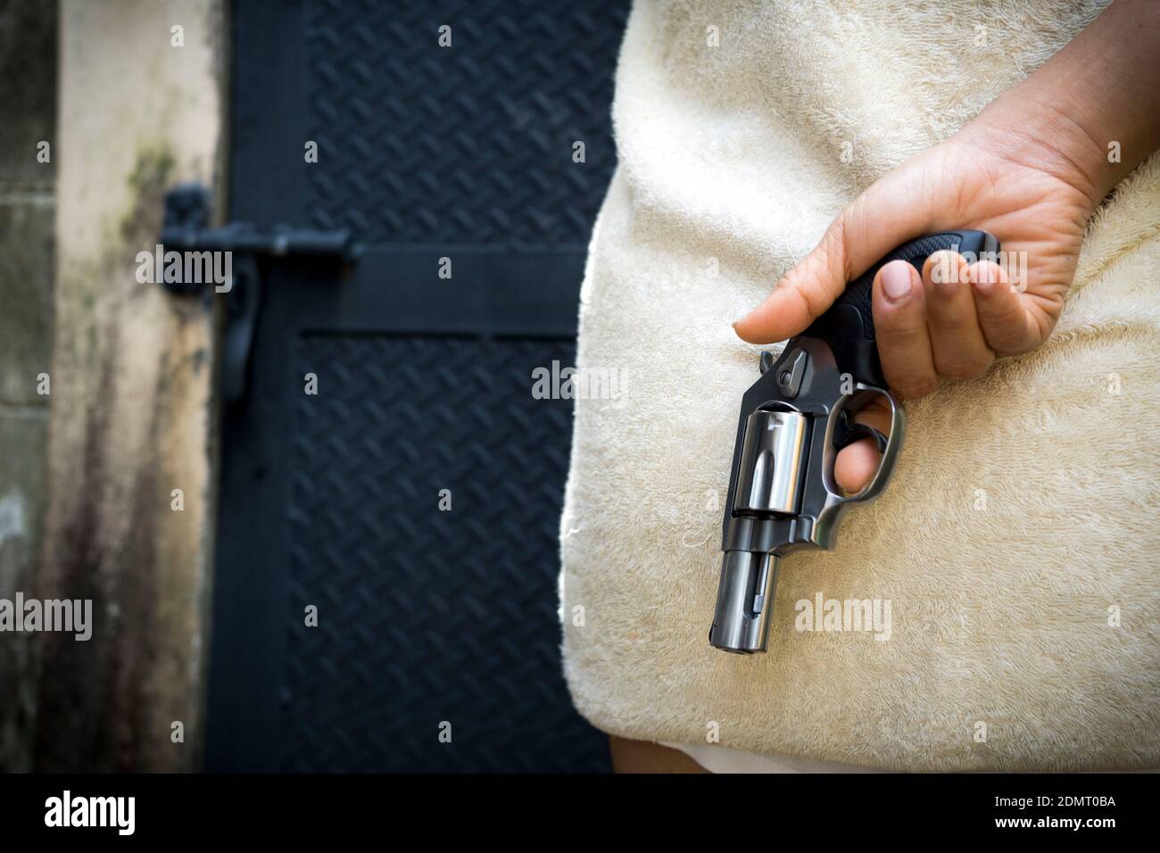 Woman holding gun her hand behind her back hi-res stock photography and ...