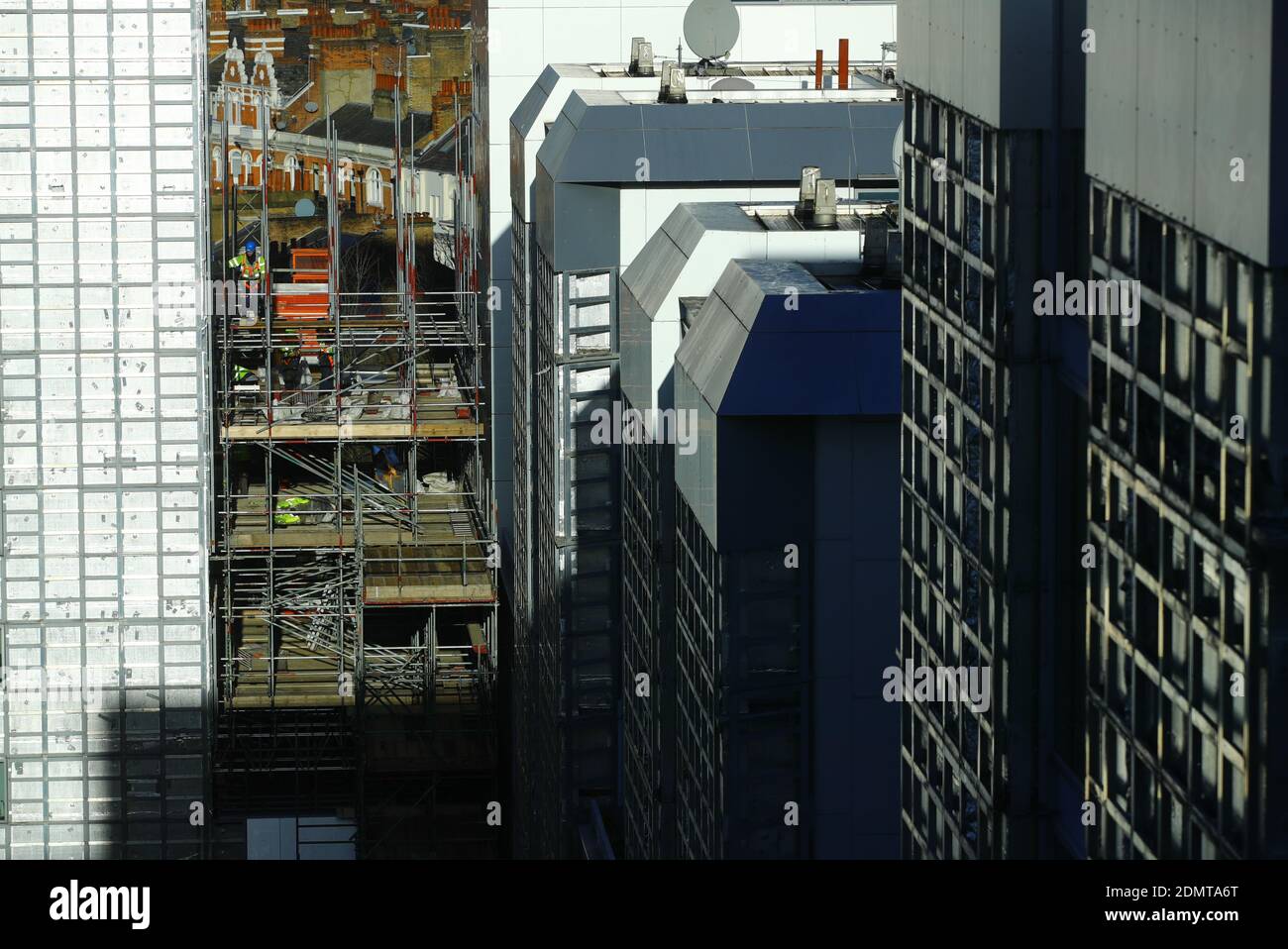 Workmen remove the cladding from the facade of a block of flats in ...