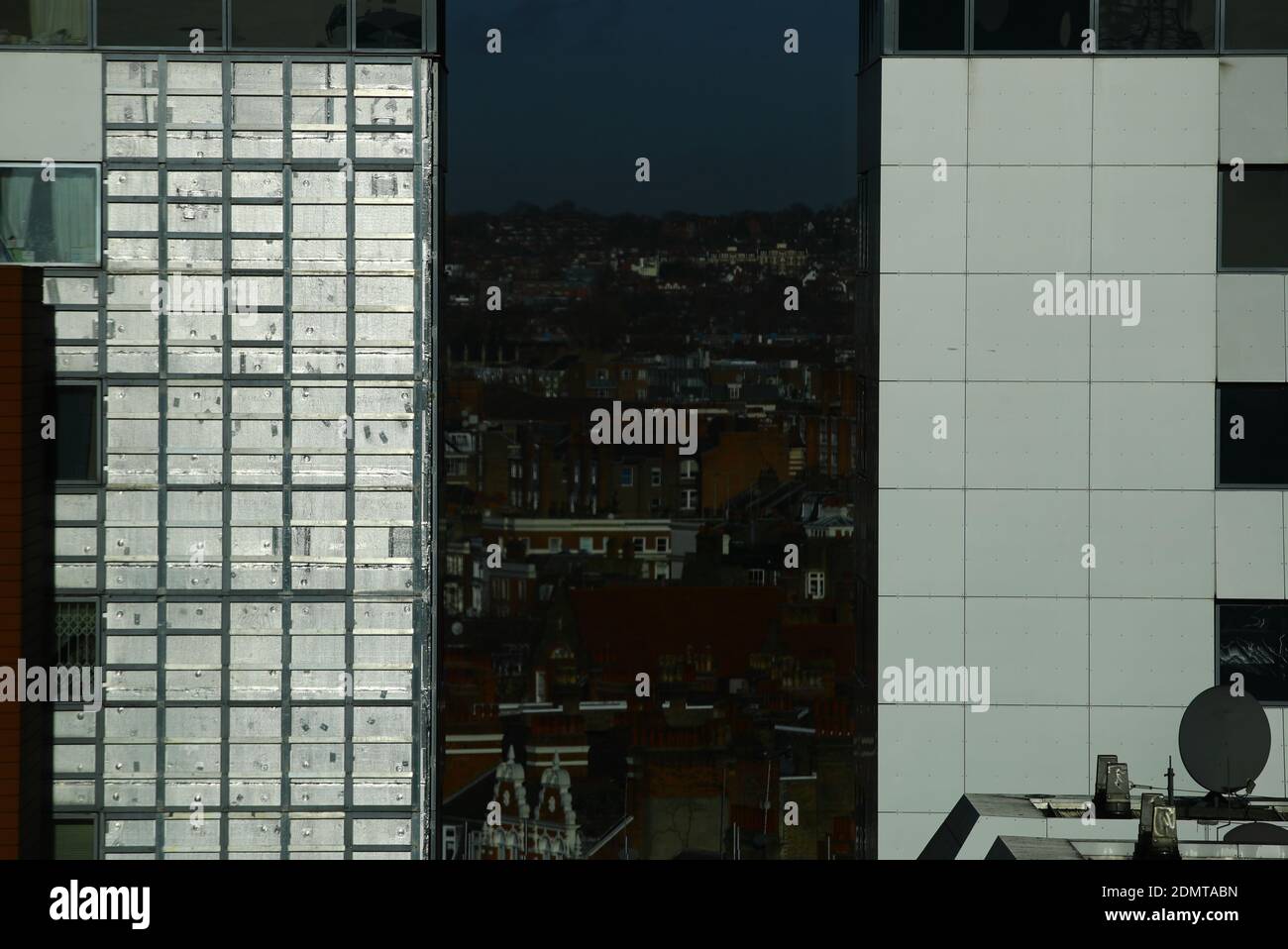 Workmen remove the cladding from the facade of a block of flats in ...