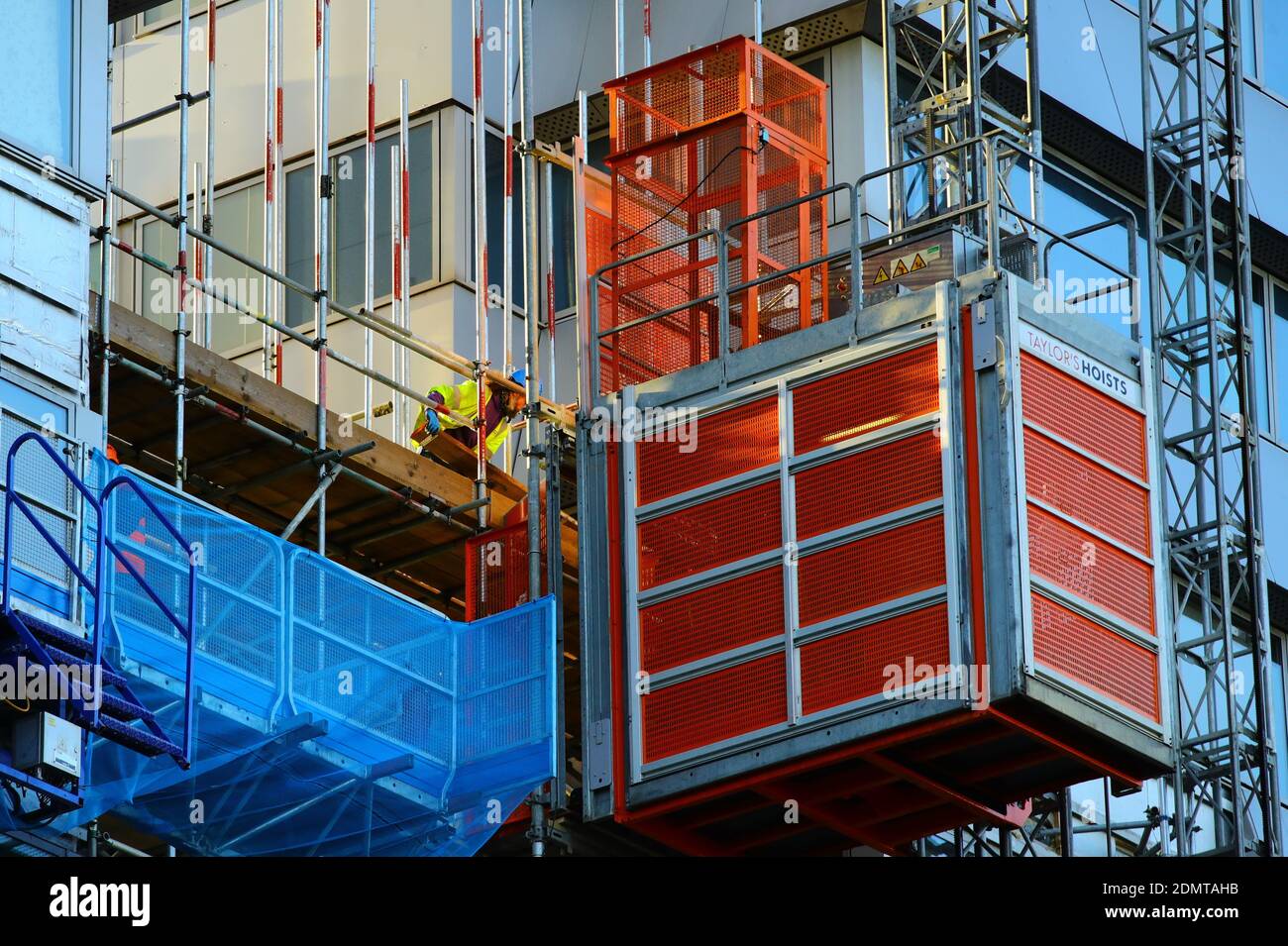 Workmen remove the cladding from the facade of a block of flats in ...