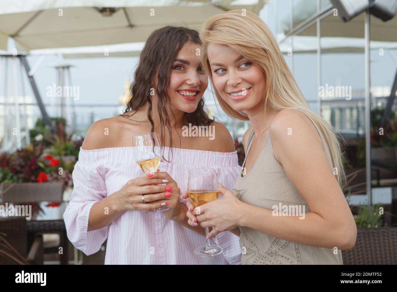 Two charming women chatting on a party at rooftop bar Stock Photo - Alamy