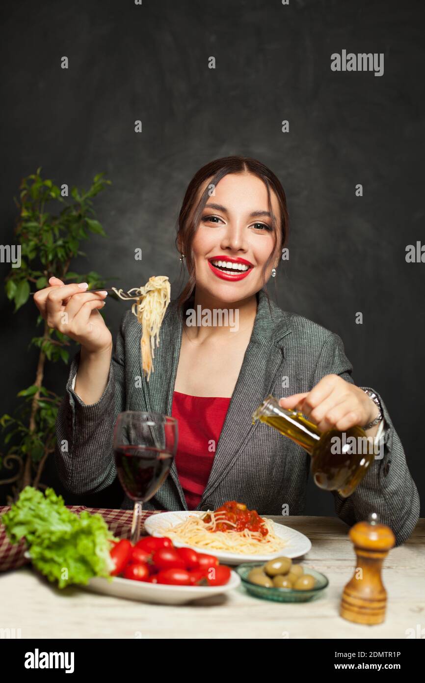 Happy beautiful woman eating italian pasta in restaurant Stock Photo ...