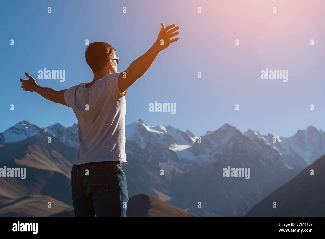 Happy man wearing sunglasses enjoys bright sunshine rays standing ...