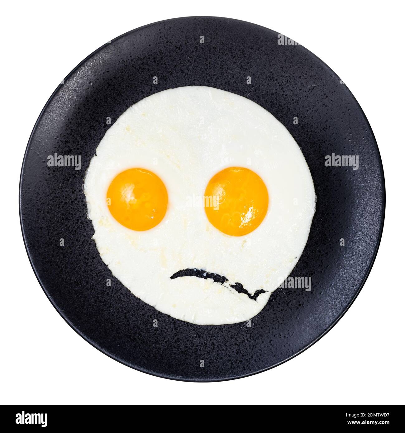 top view of fried eggs on black plate isolated on white background ...