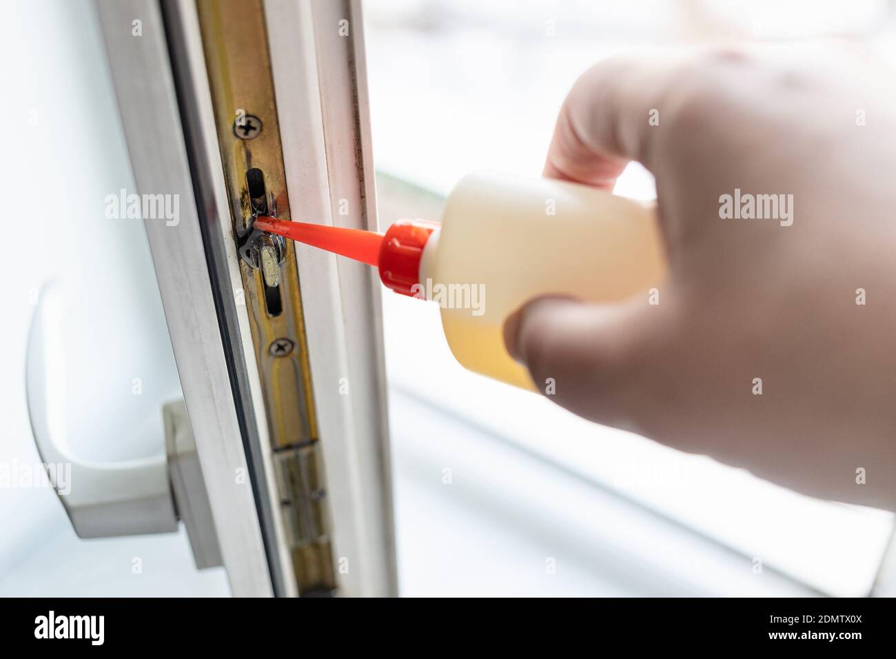 lubricating window frame details with oil from oiler close up at home ...