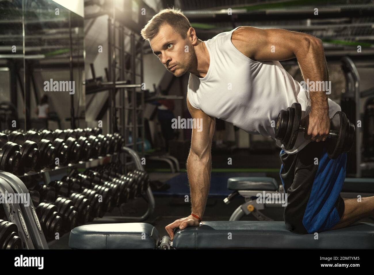 Passion for sports. Handsome young muscular athletic man exercising at ...