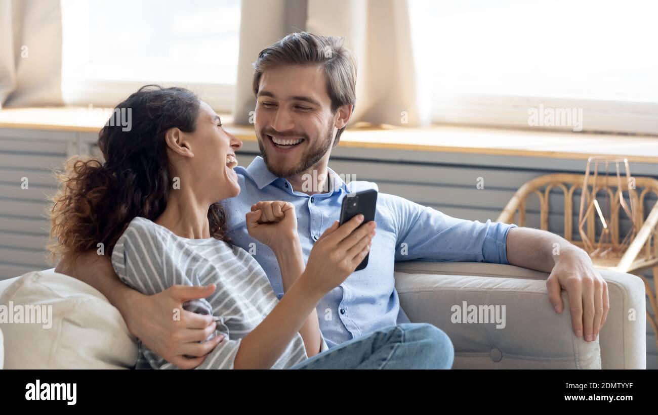 Banner view of happy couple celebrate win on smartphone Stock Photo - Alamy