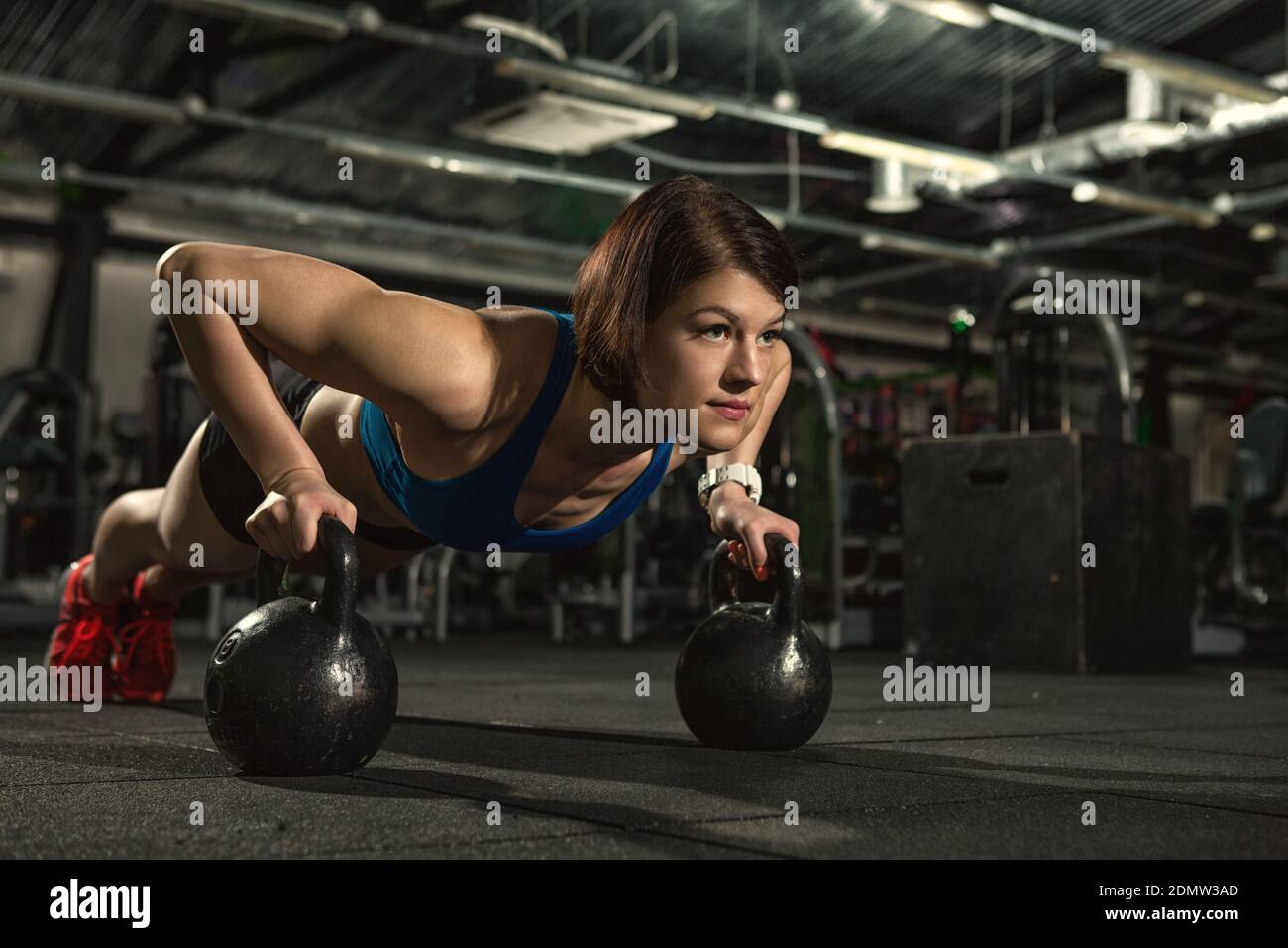 Life of fitness. Attractive young gym fitness woman doing pushups with ...